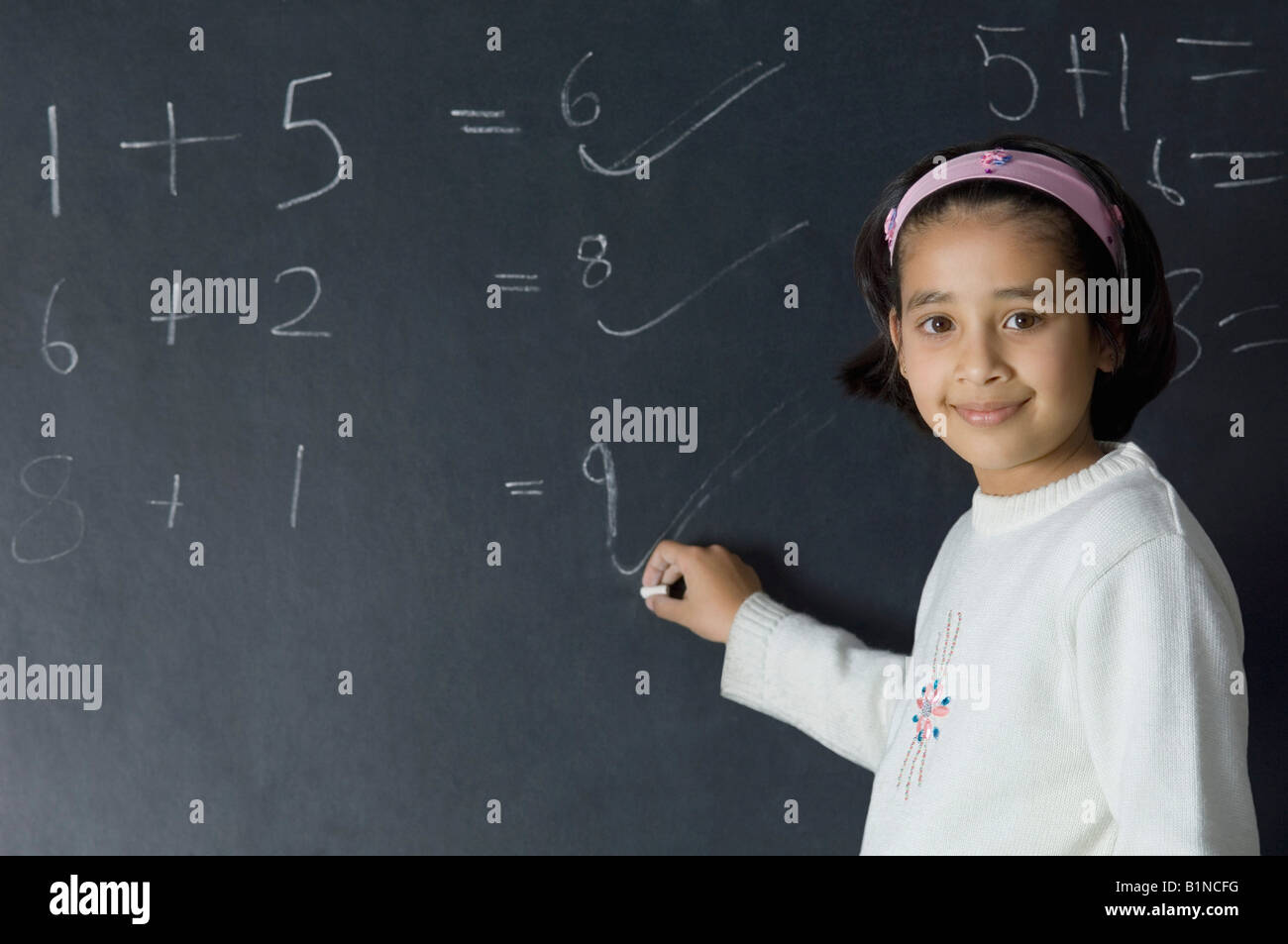 Portrait of a girl solving mathematical symbols on a blackboard Stock ...