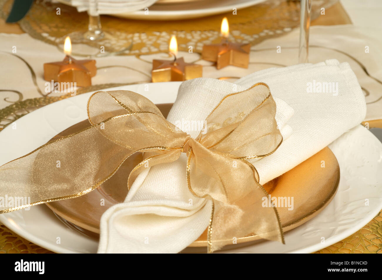 Christmas table place setting, napkin tied with a golden ribbon Stock ...