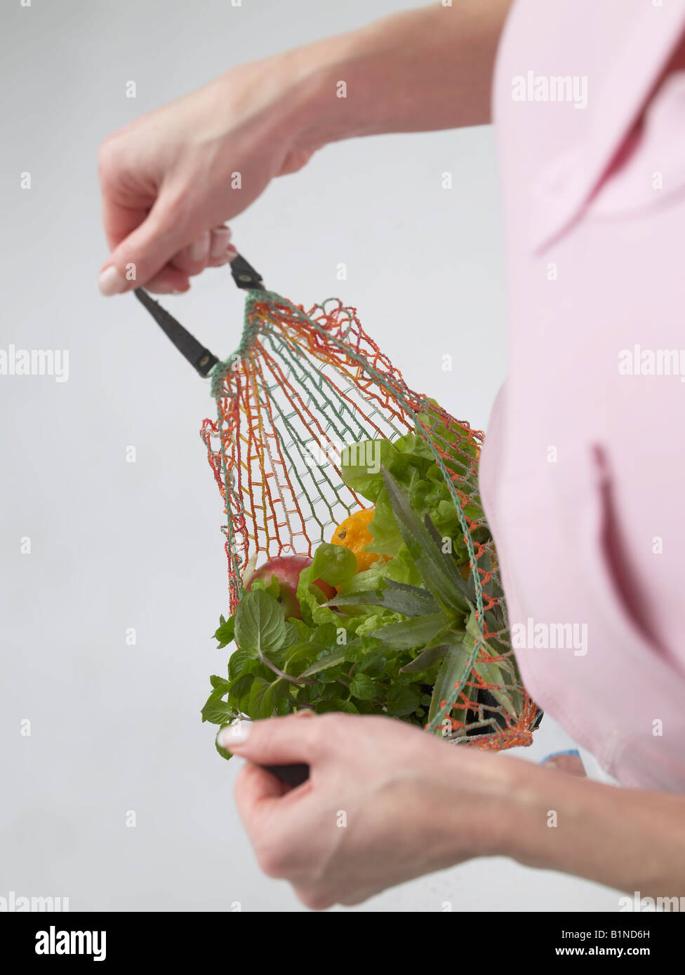 Woman with fruit and vegetables in a string bag Stock Photo - Alamy