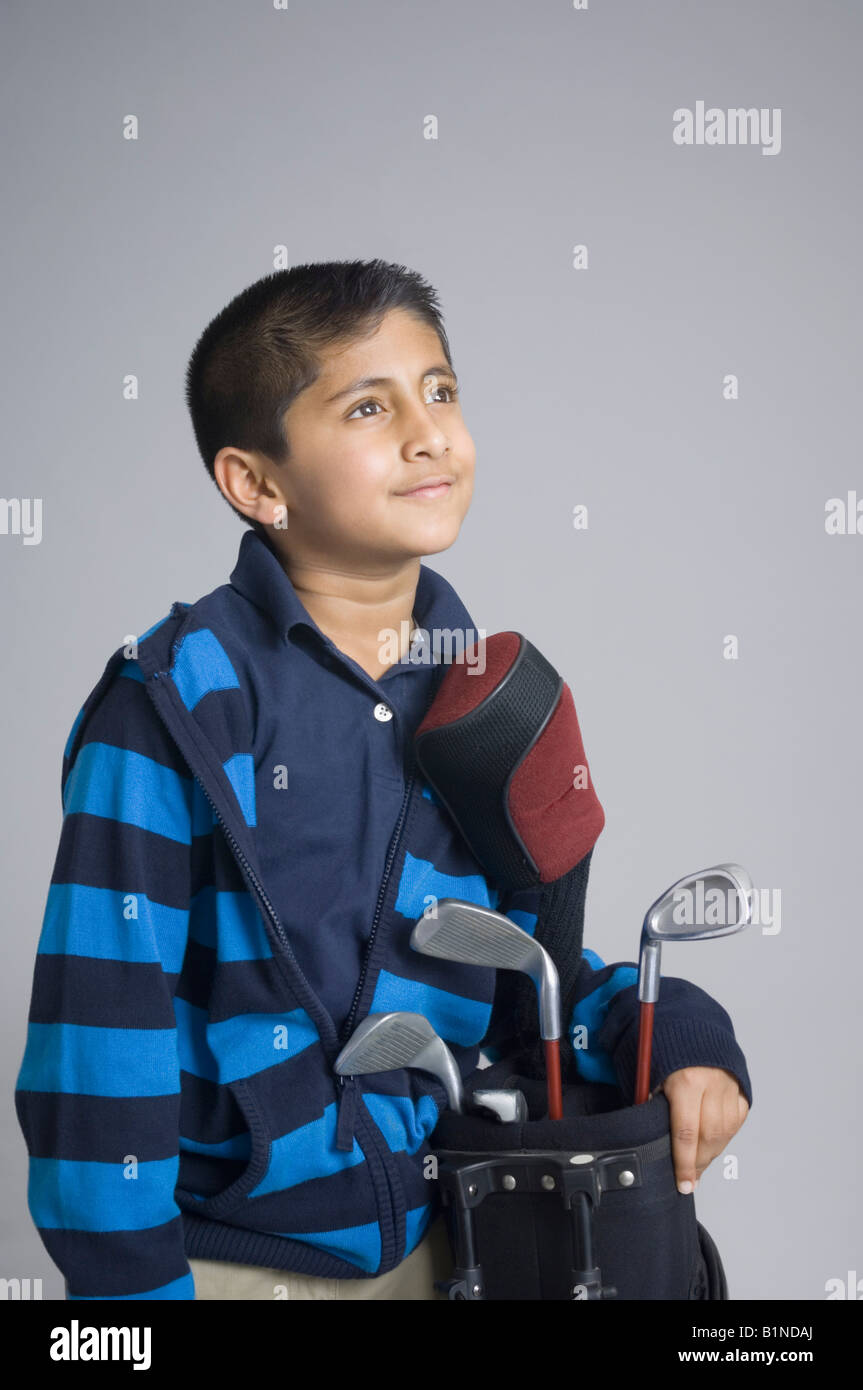 Boy carrying a golf bag and smiling Stock Photo - Alamy