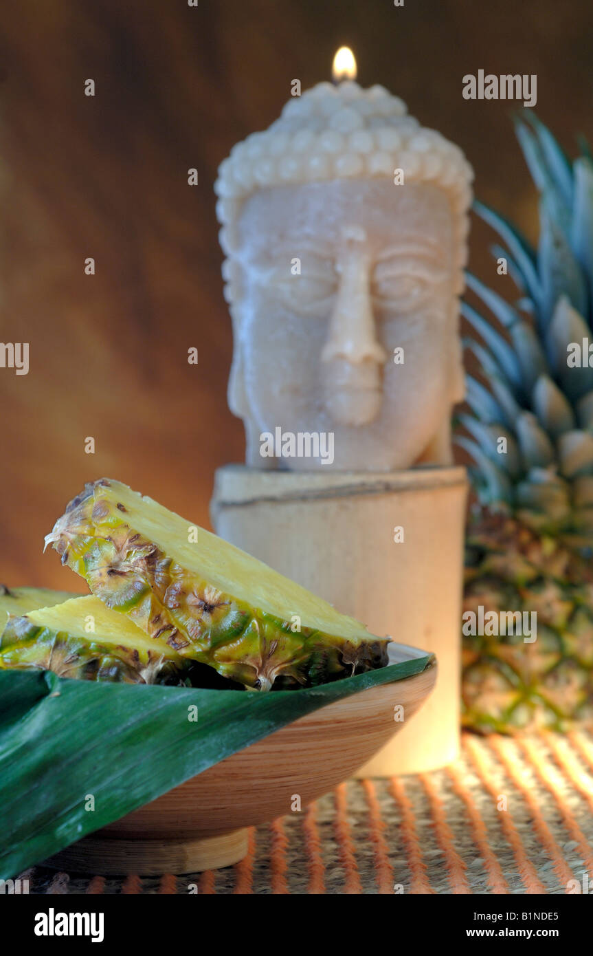 Pineapple and a Buddha candle Stock Photo - Alamy