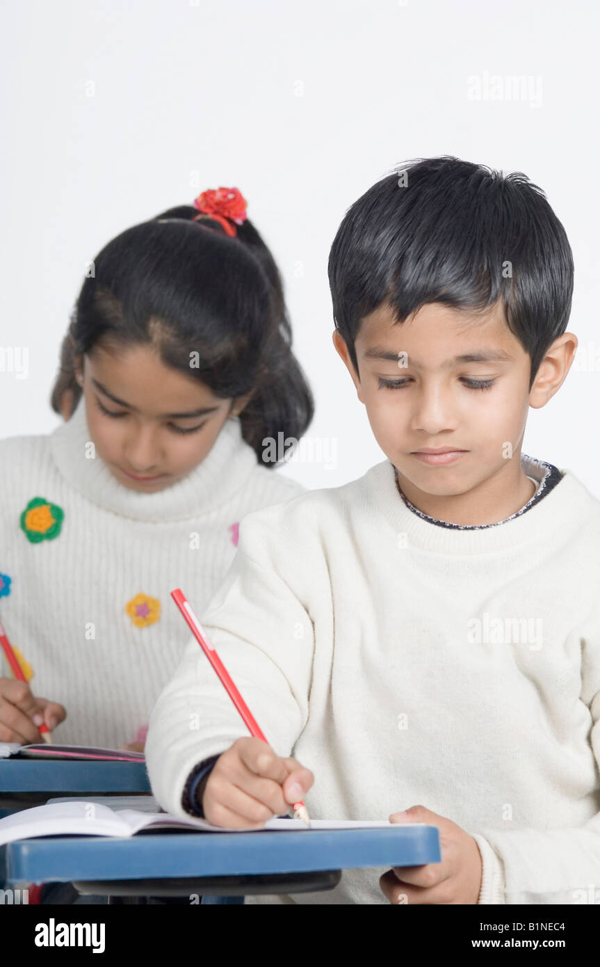 Boy and girl sitting in a classroom and studying Stock Photo - Alamy