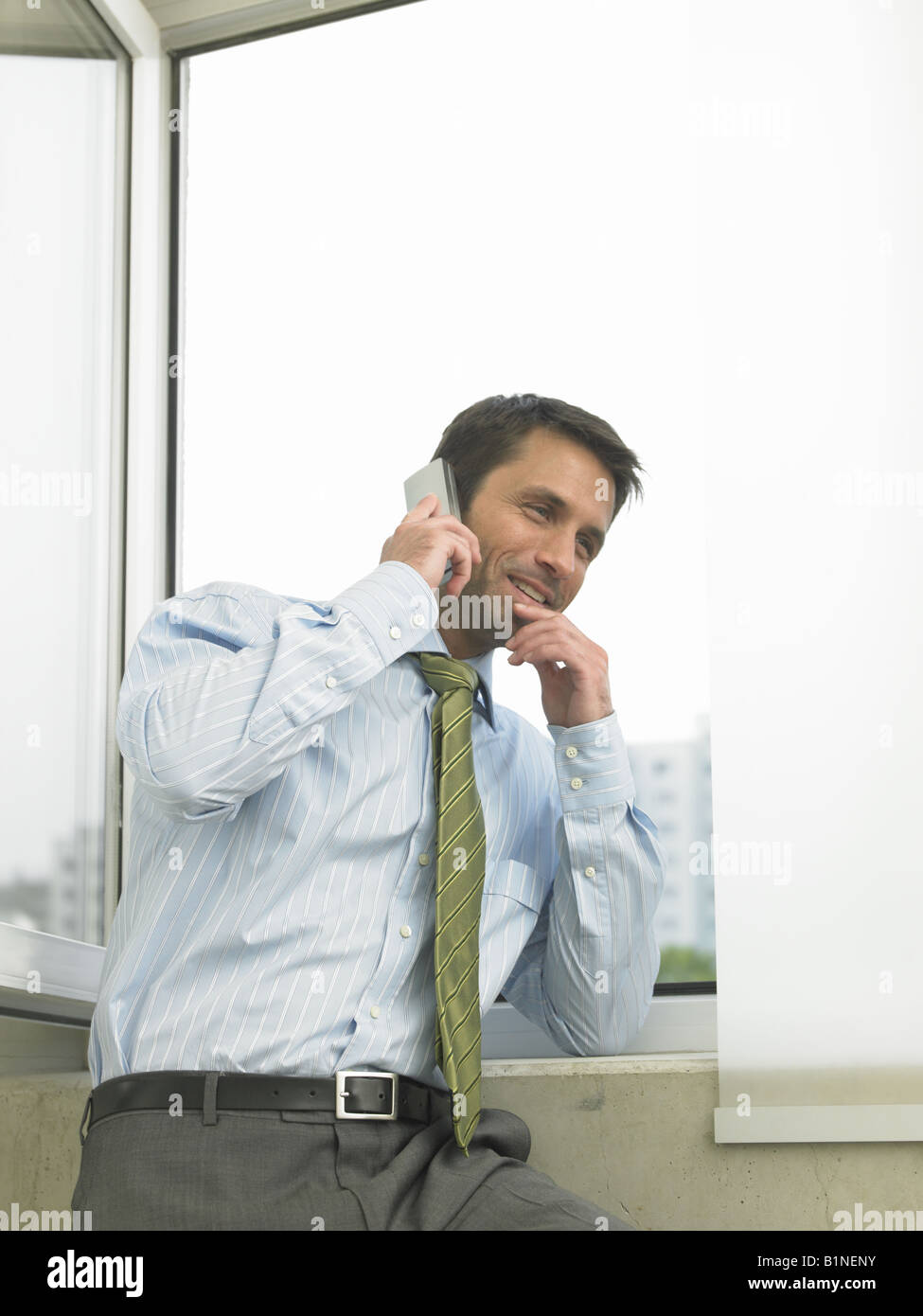 Business man is phoning at the window Stock Photo - Alamy