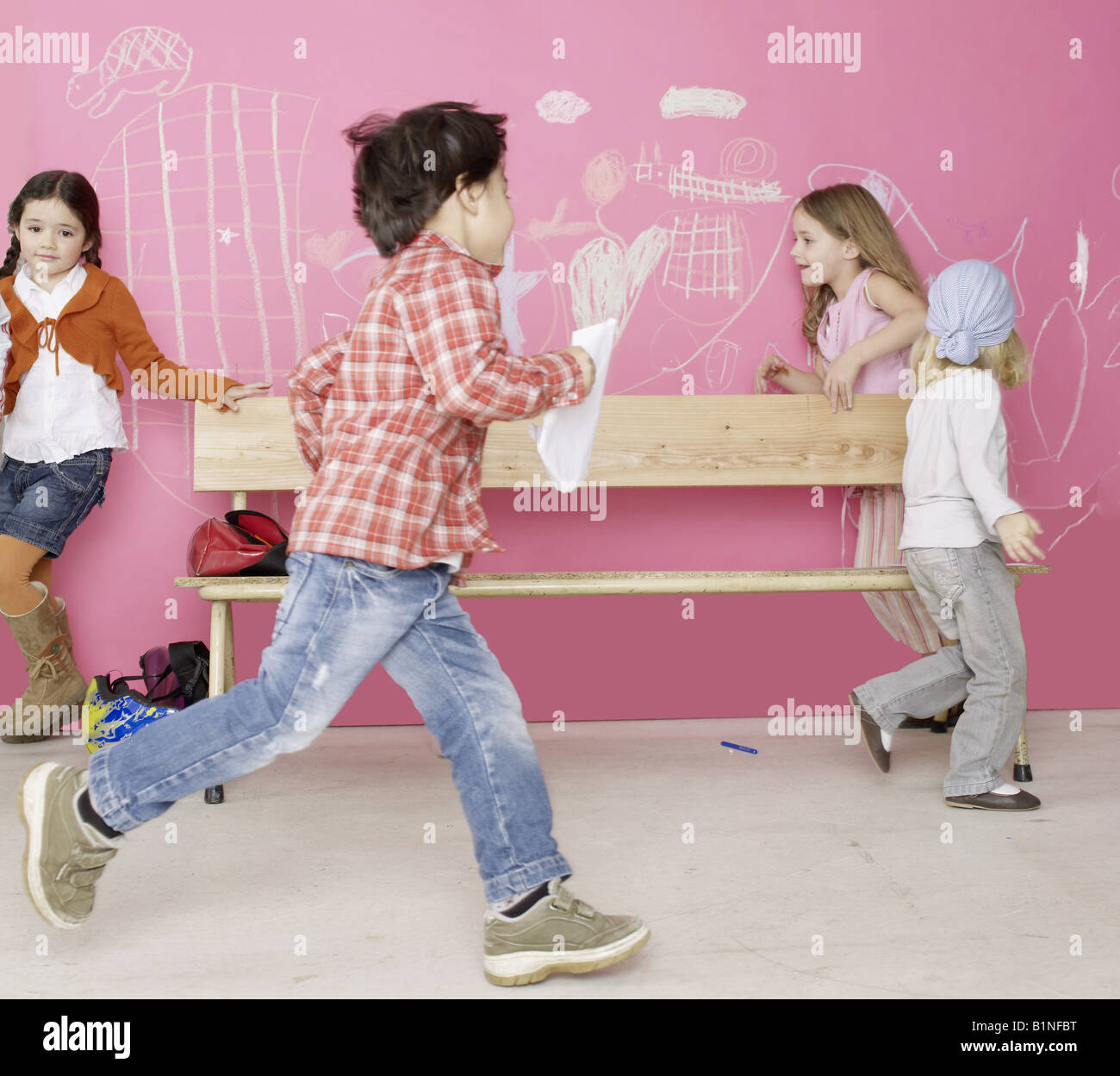 Children running around a bench Stock Photo - Alamy