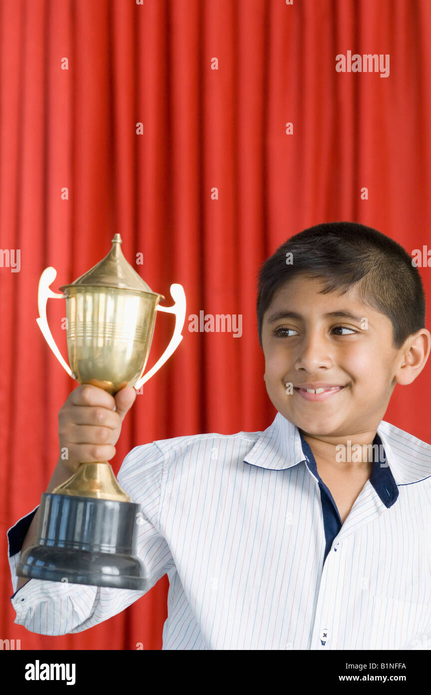 Boy holding a trophy and smiling Stock Photo - Alamy