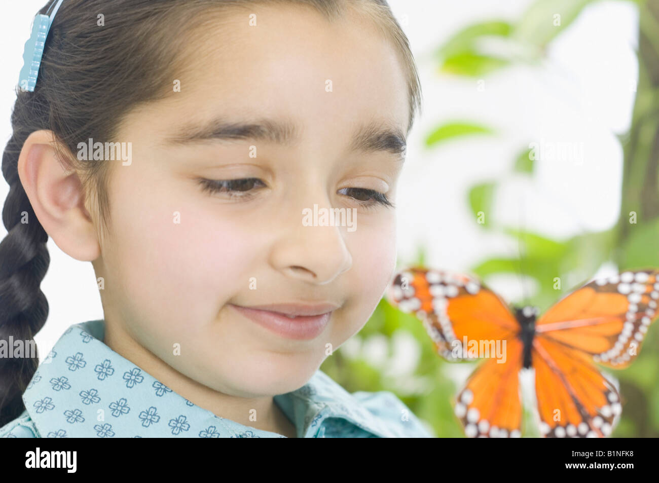 Close-up of a girl looking at a butterfly Stock Photo - Alamy