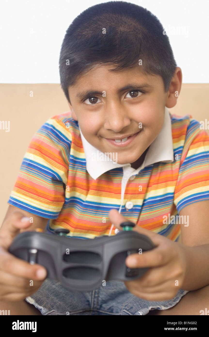 Portrait of a boy playing video game and smiling Stock Photo - Alamy