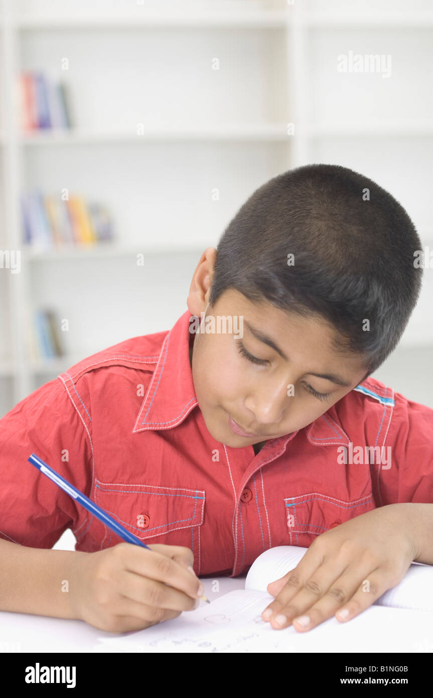 Boy writing with a pencil on a notepad Stock Photo - Alamy