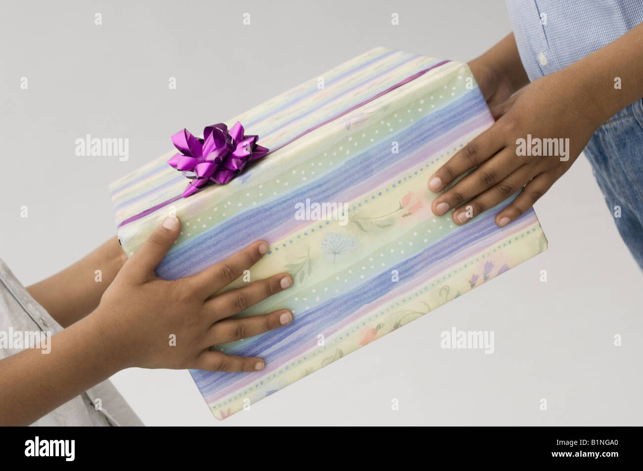 Mid section view of a child giving a gift to another child Stock Photo ...