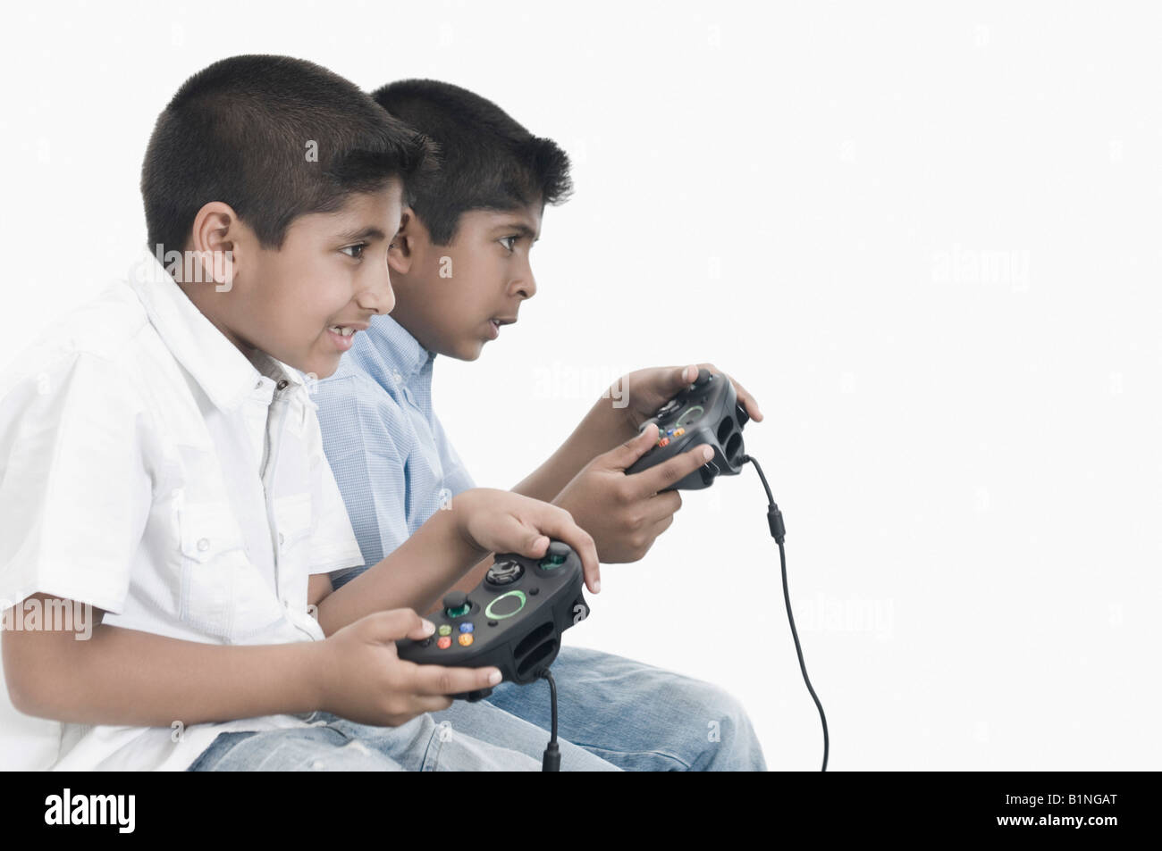 Side profile of two boys playing video game Stock Photo - Alamy