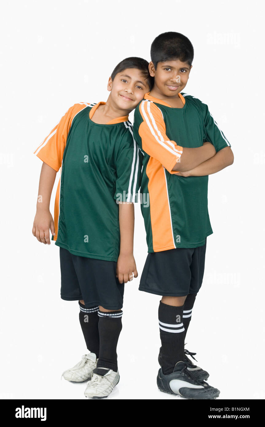 Portrait of two boys wearing sports clothing and standing back to back ...