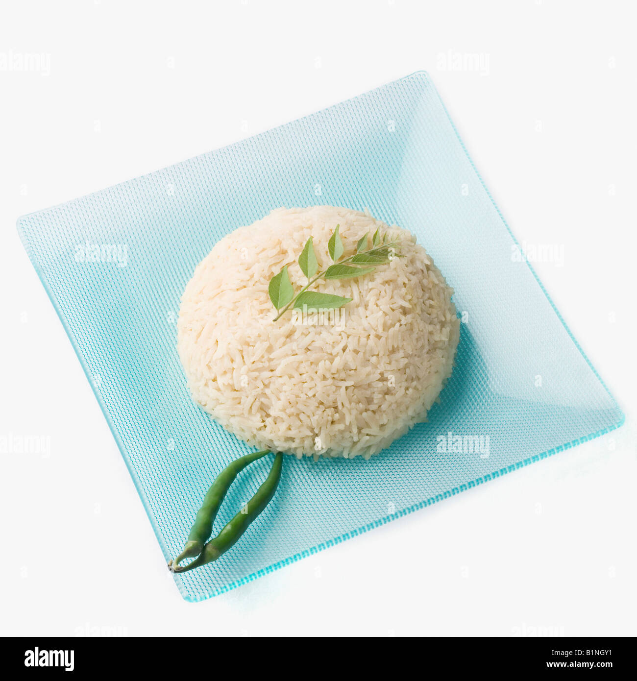Close-up of boiled rice with green chili pepper and curry leaves in a ...