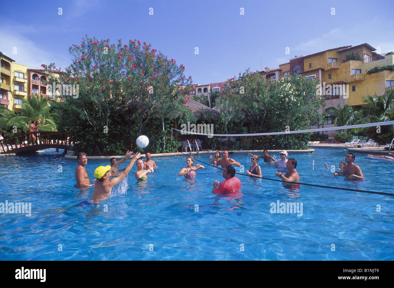 Hotel guests and friends join in for a friendly water volleyball game ...