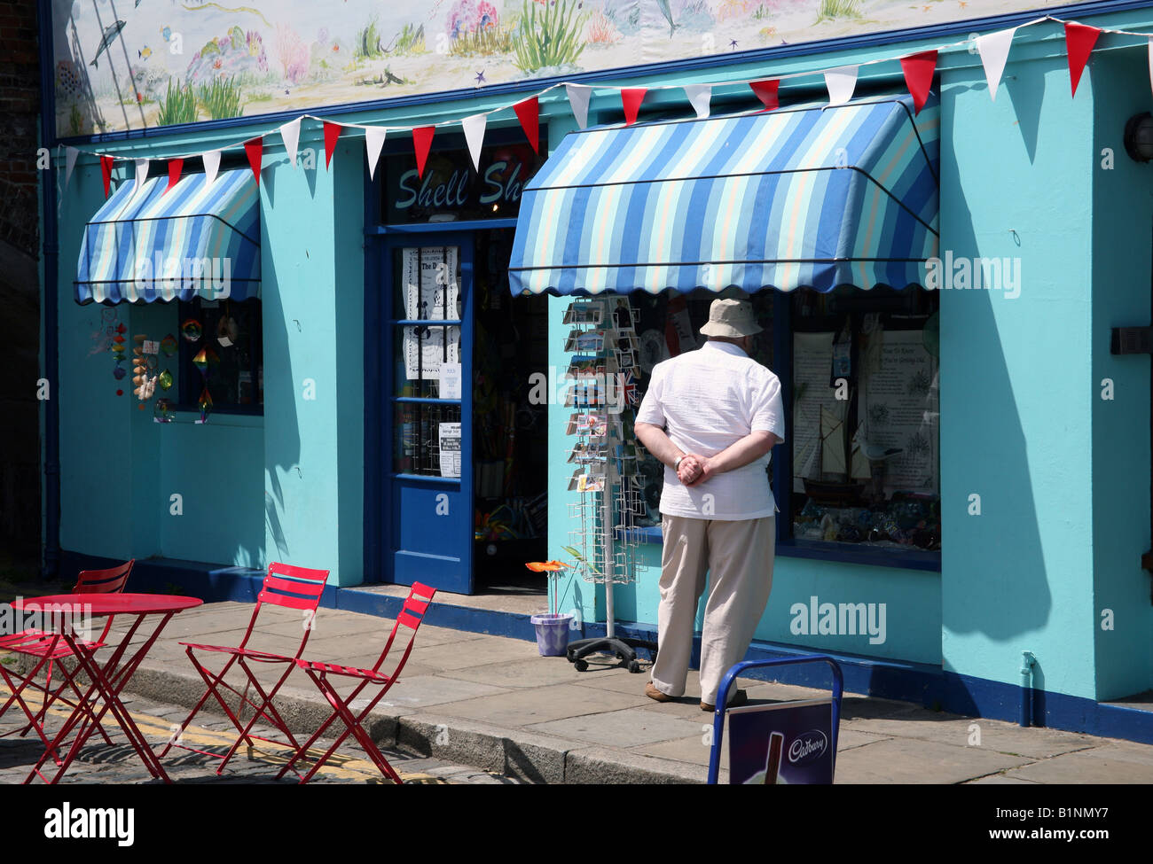 Man looking in window of seaside gift shop, England Stock Photo - Alamy