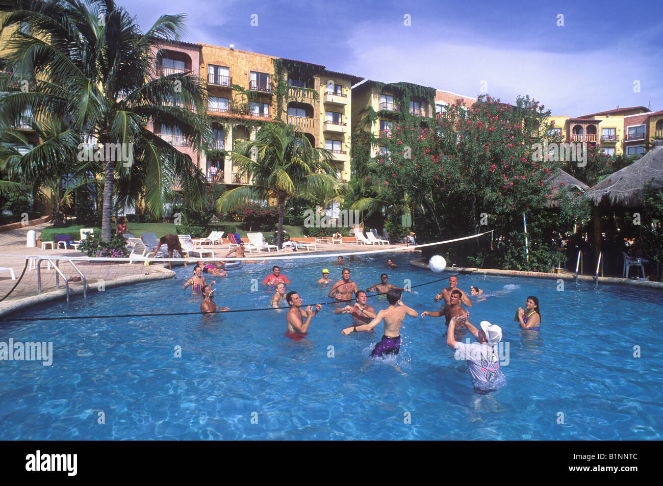 Hotel guests and friends join in for a friendly water volleyball game ...