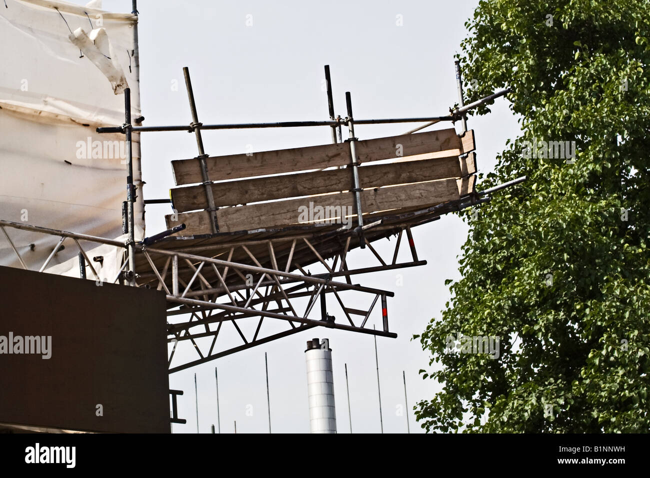 Scaffolding and wooden platform on side of building Stock Photo - Alamy