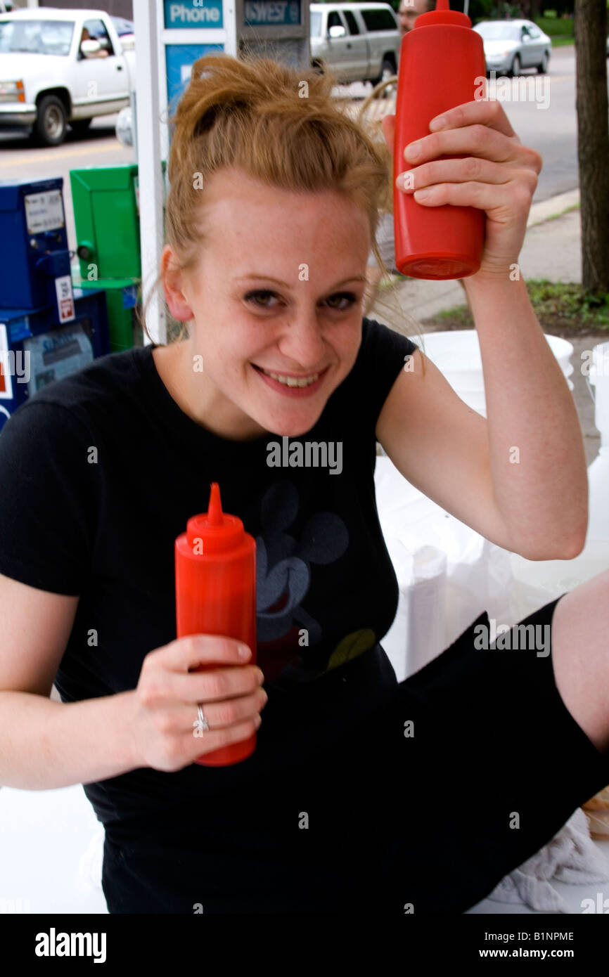Woman age 18 at food concession stand dancing with catchup dispensers ...