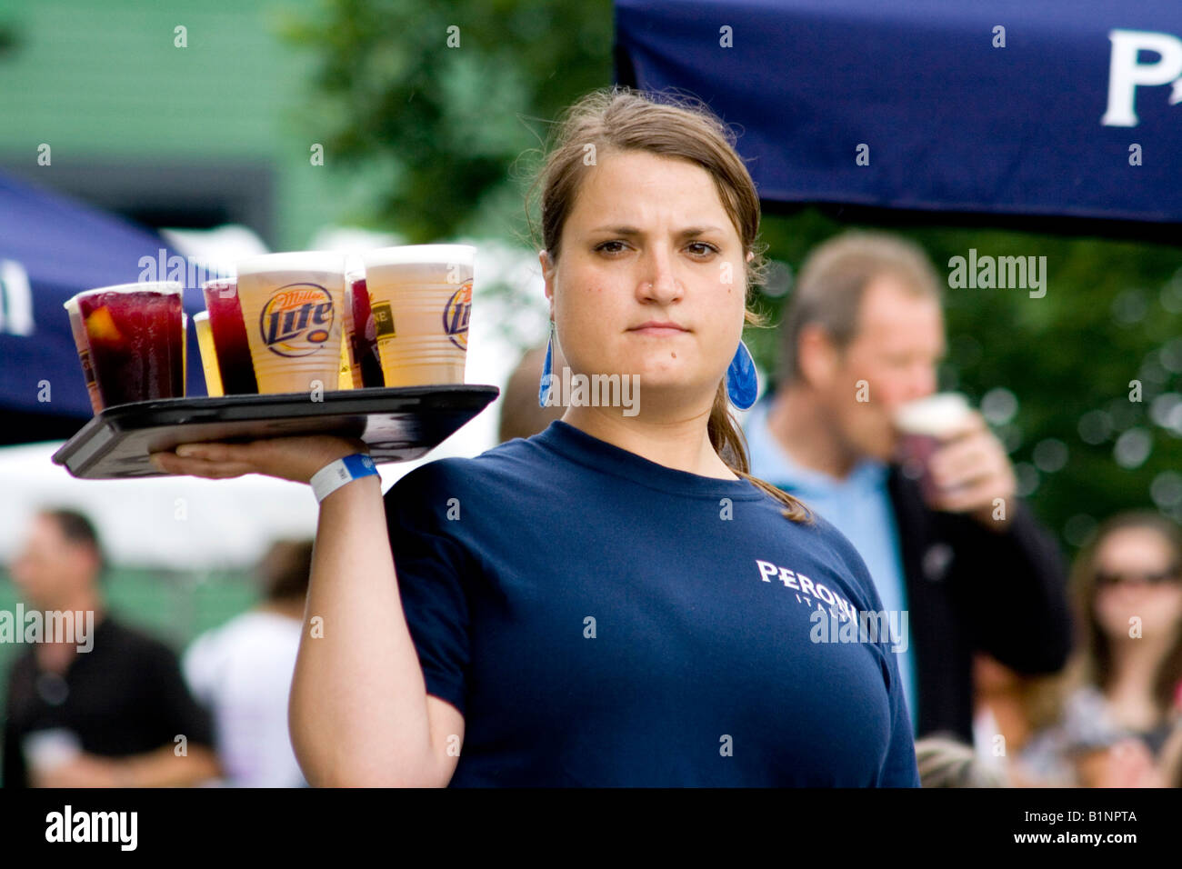 Strong armed waitress delivering a tray of beer and other beverages ...