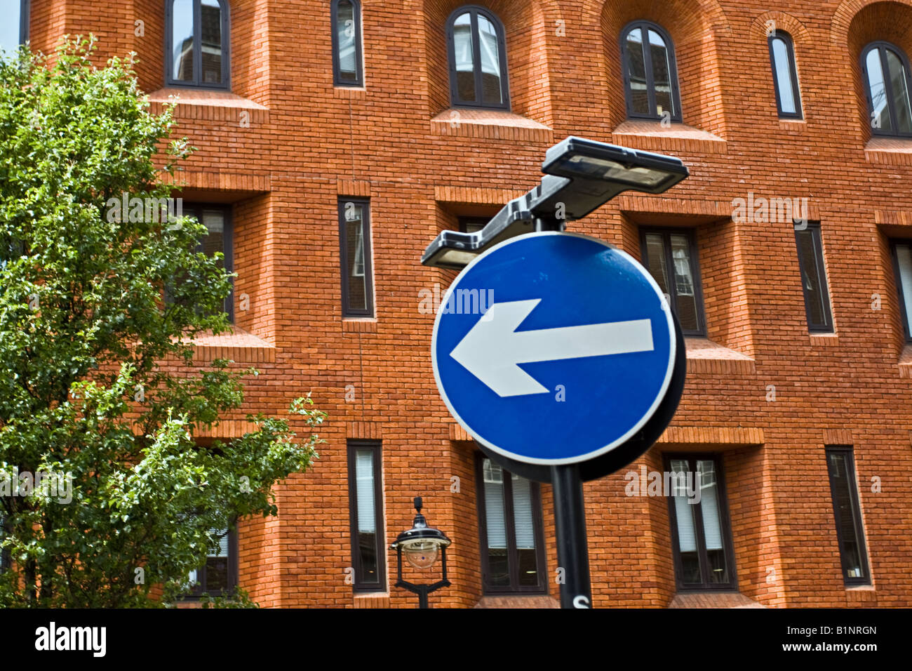 Turn left sign in Soho London with red brick building in background ...