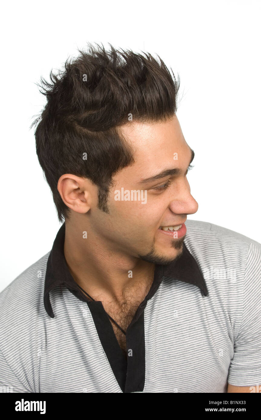 Young man looking to the side smiling against a white background Stock ...