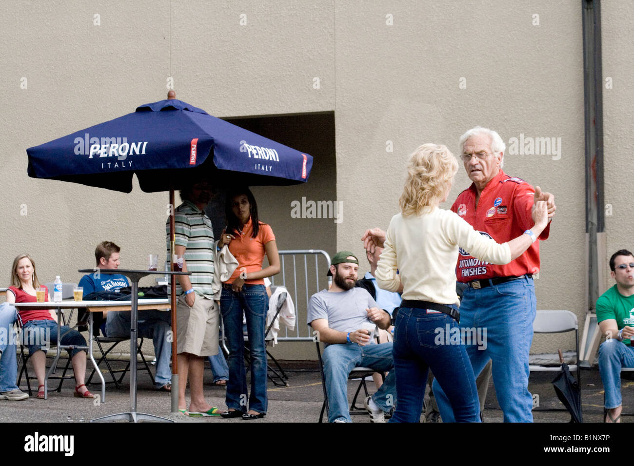 Sporty older couple age 66 and 40 dancing in beer garden. Grand Old Day ...