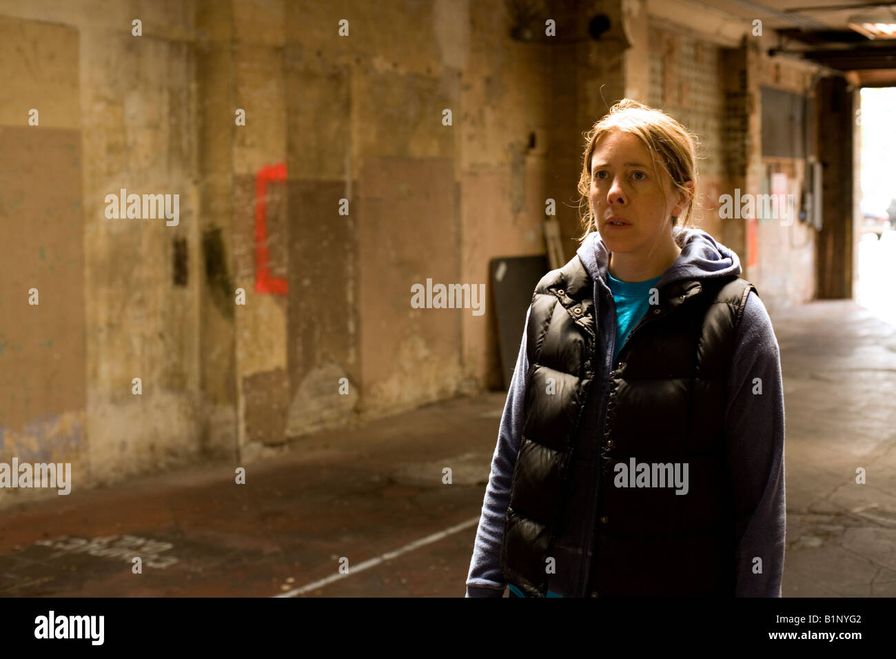 Girl in old worn down garage looking at something out of camera Stock ...