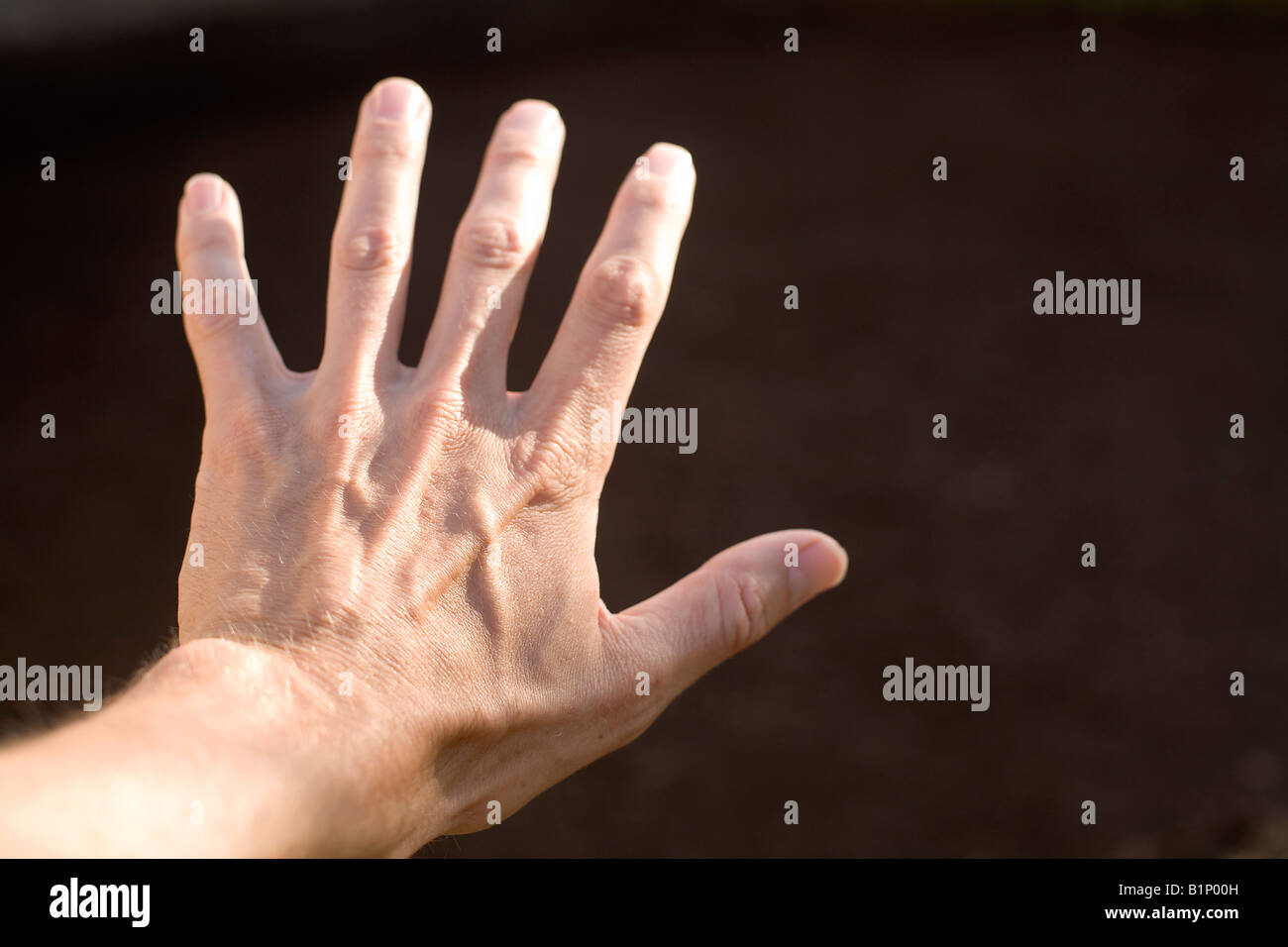white hand reaching out into blackness Stock Photo - Alamy