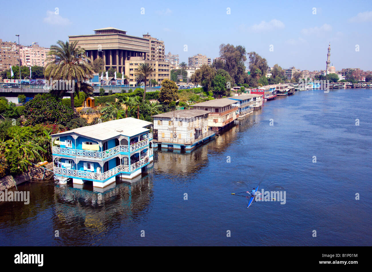A lone rowing boat or shell and a row of houseboats moored on the west ...
