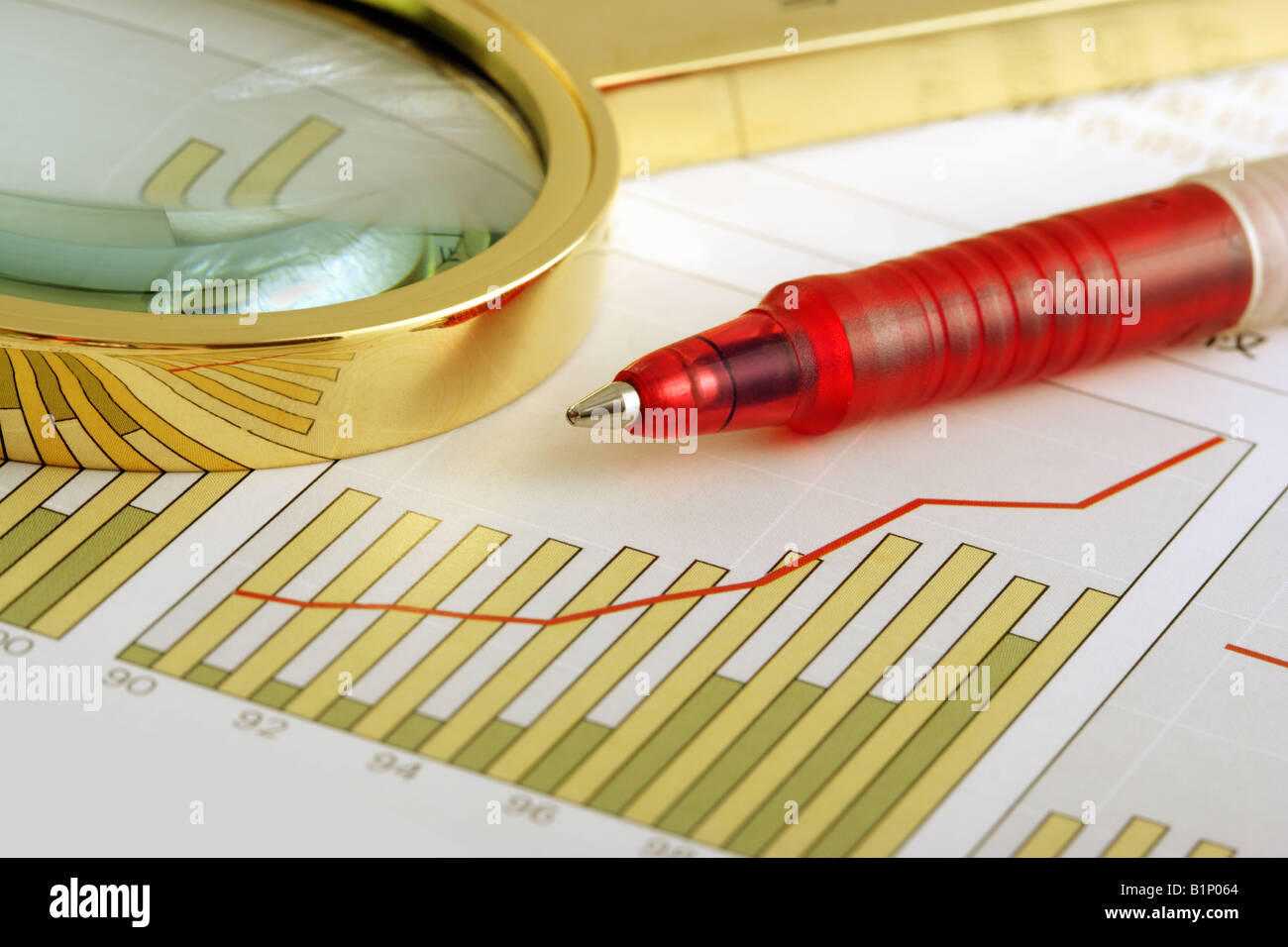 A ball point pen and a magnifying glass focusing on a chart Stock Photo ...
