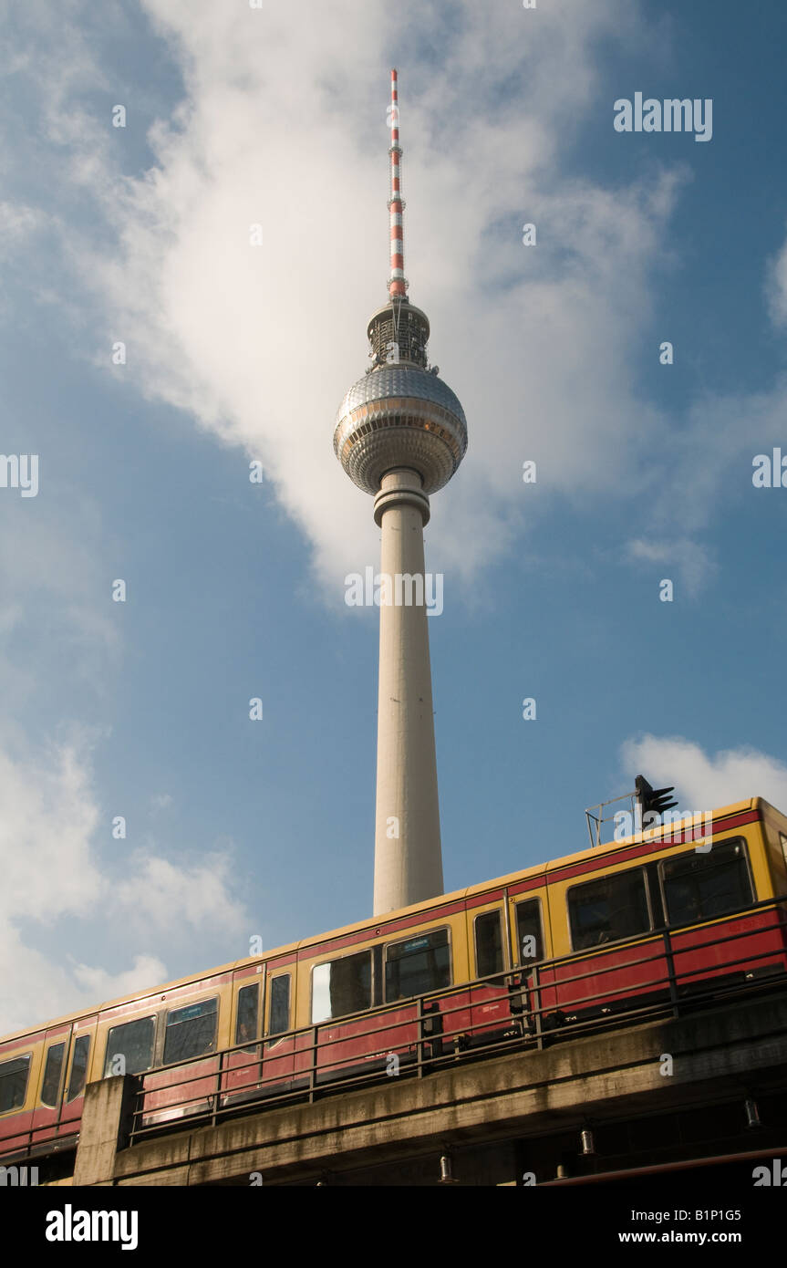 An S-Bahn train pass by the Fernsehturm communication antenna tower ...