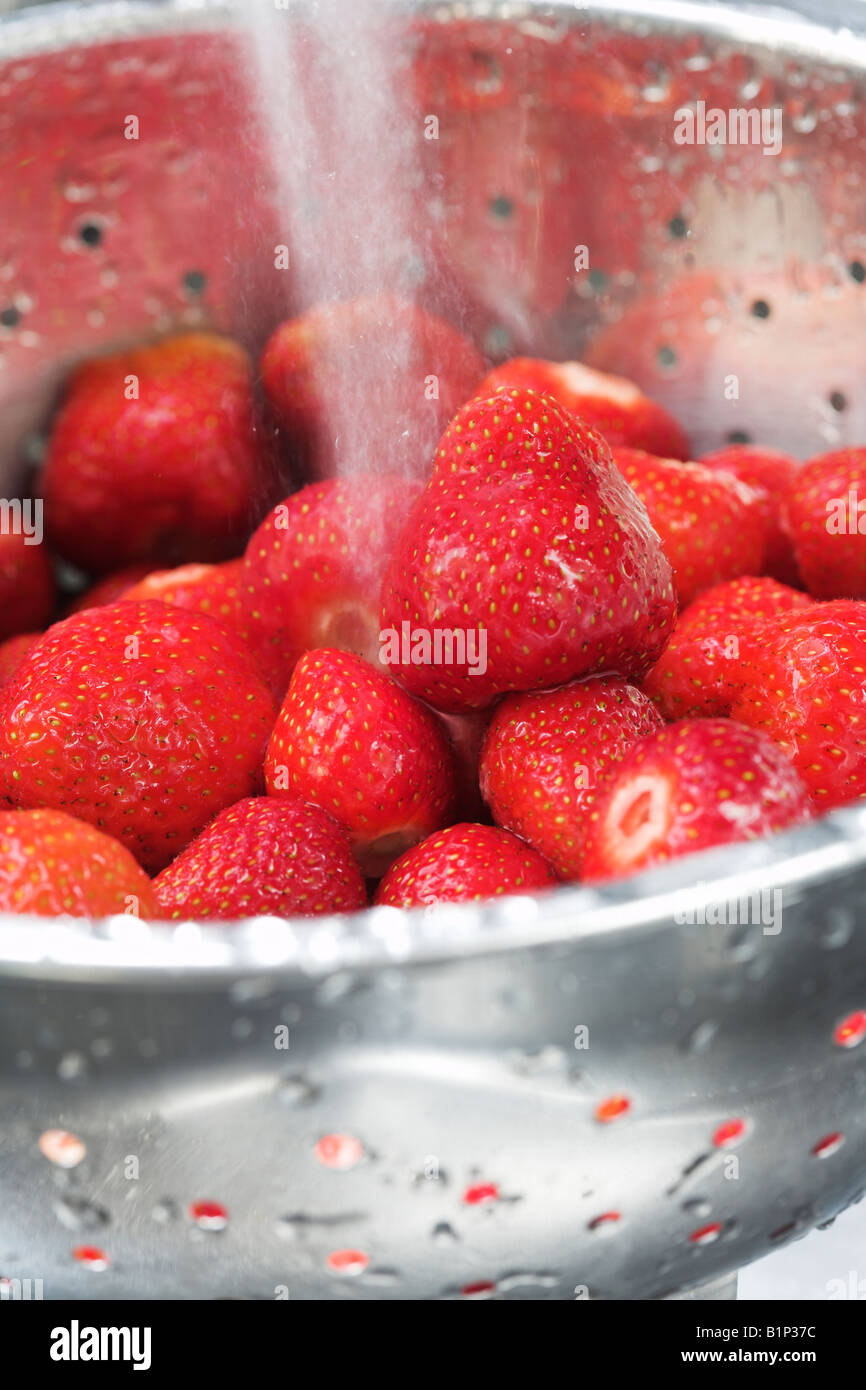 Vertical, colour image of strawberries being washed Stock Photo - Alamy