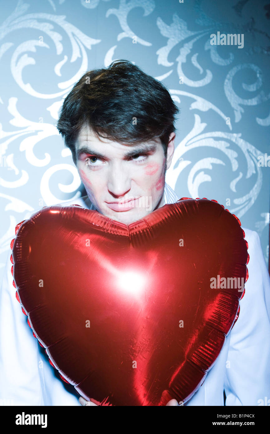Angry man with red heart balloon Stock Photo - Alamy