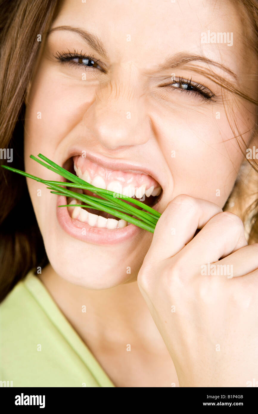 Woman eating spring onion Stock Photo - Alamy