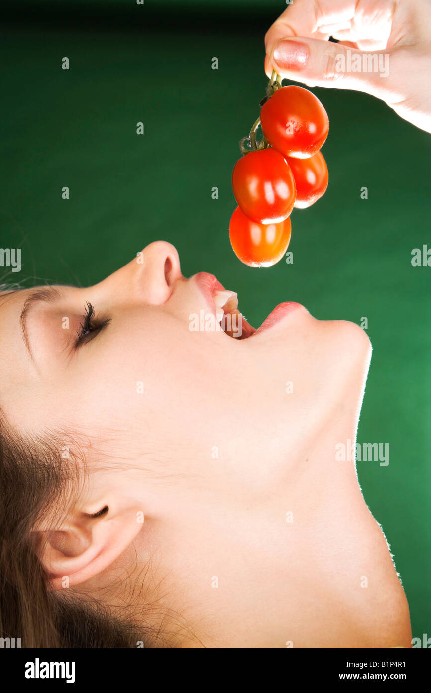 Woman eating tomatoes Stock Photo - Alamy