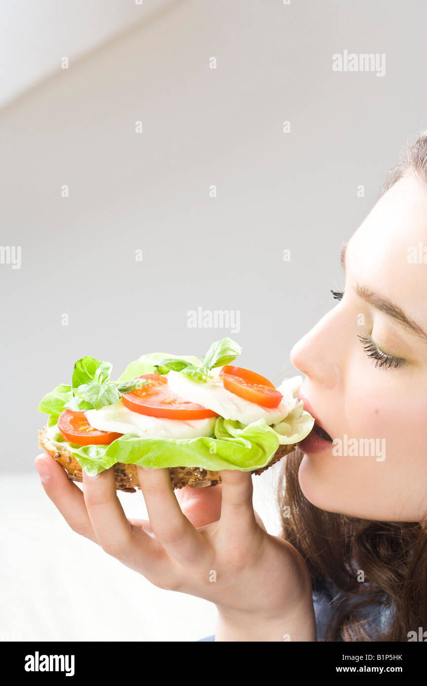 Young woman eating sandwich Stock Photo - Alamy