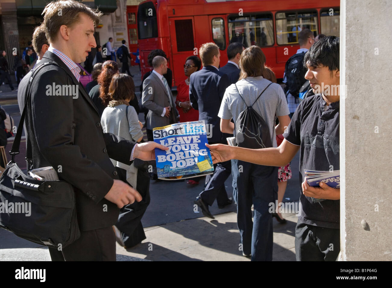 a man handing out a magazine in London Stock Photo - Alamy
