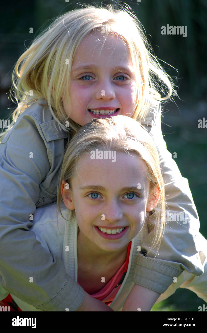 Photograph of two friends playing together and smiling having fun and ...