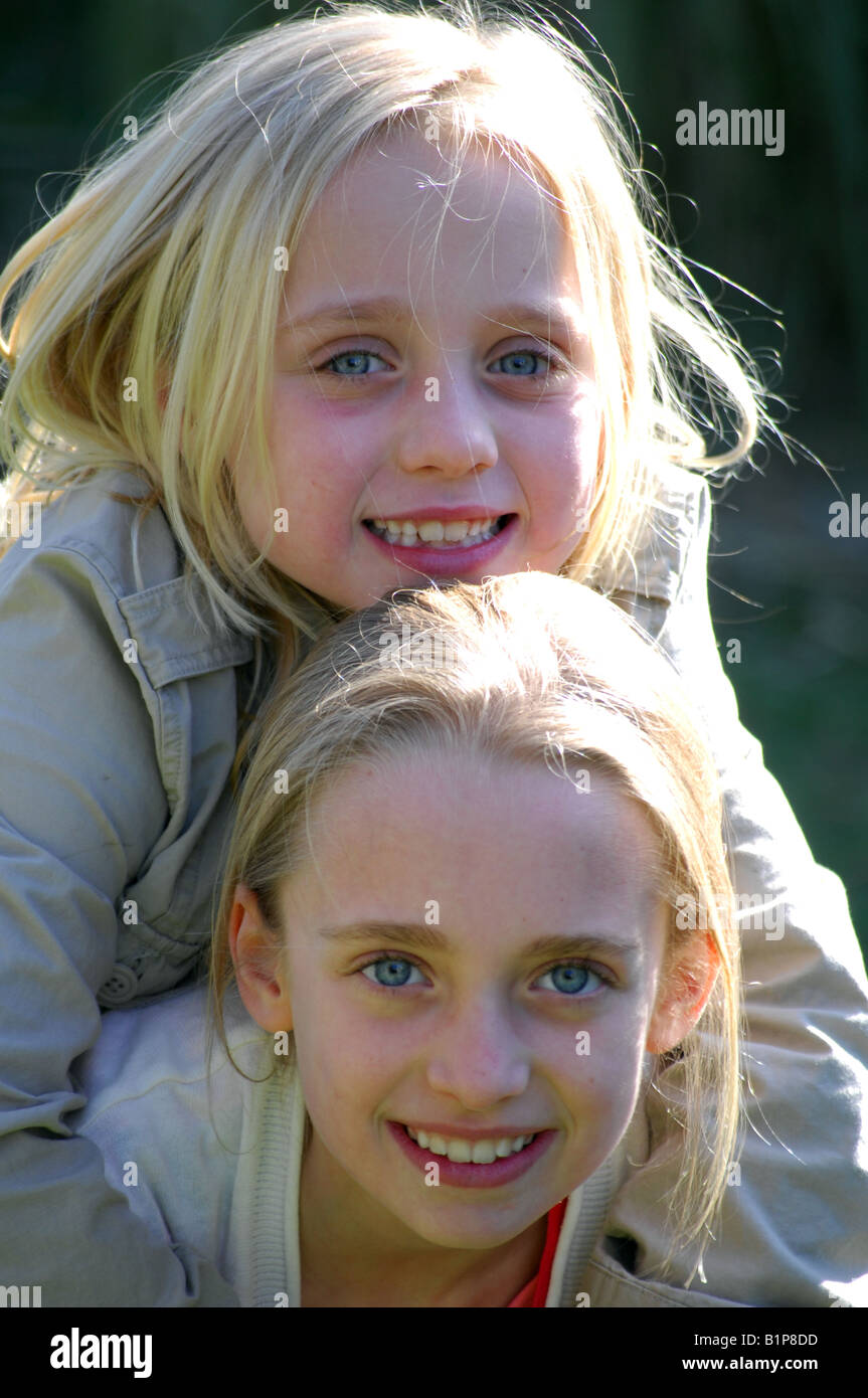 Photograph of two friends playing together and smiling having fun and ...