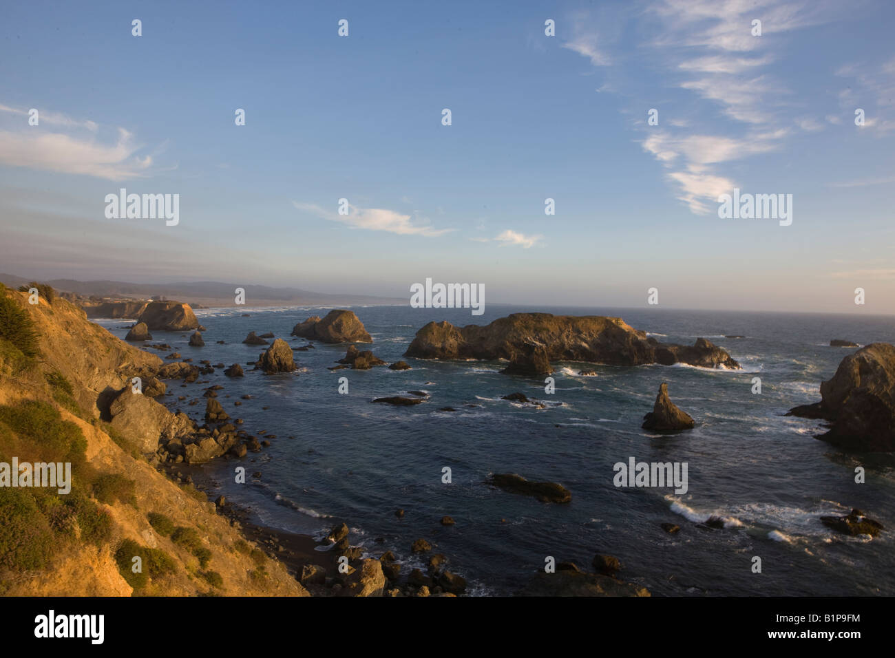 Steep cliffs and rocks line the shore of the Pacific Ocean along ...