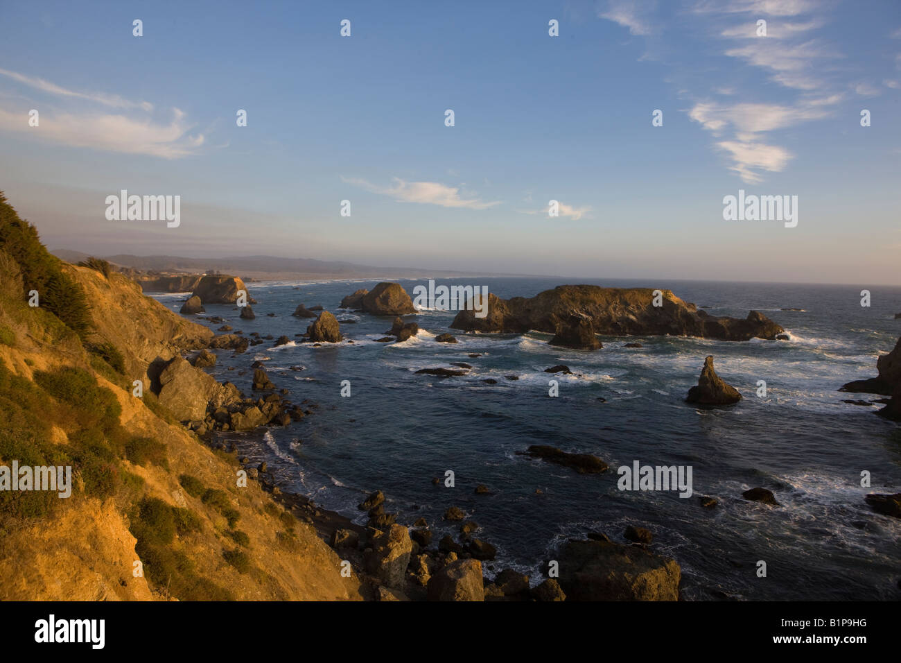 Steep cliffs and rocks line the shore of the Pacific Ocean along ...