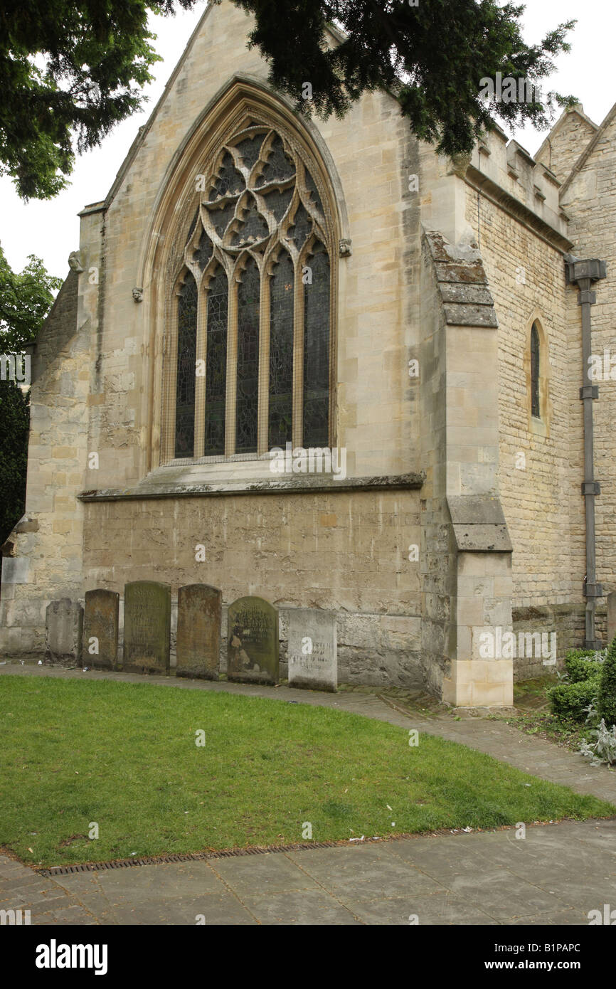 Church wall with a stained glass window with grave stone beneath the ...