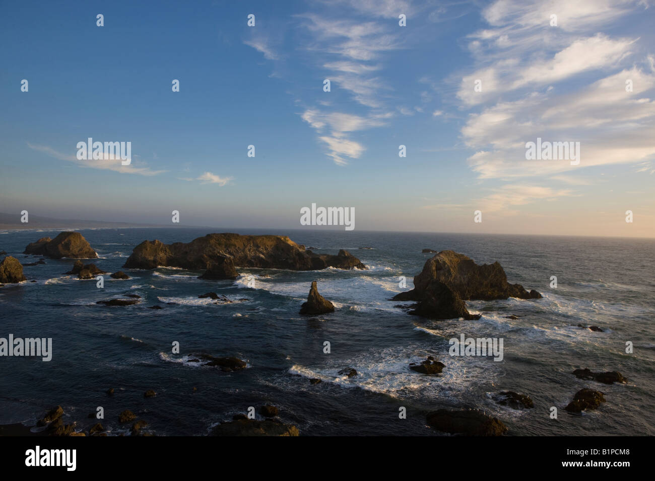 Steep cliffs and rocks line the shore of the Pacific Ocean along ...