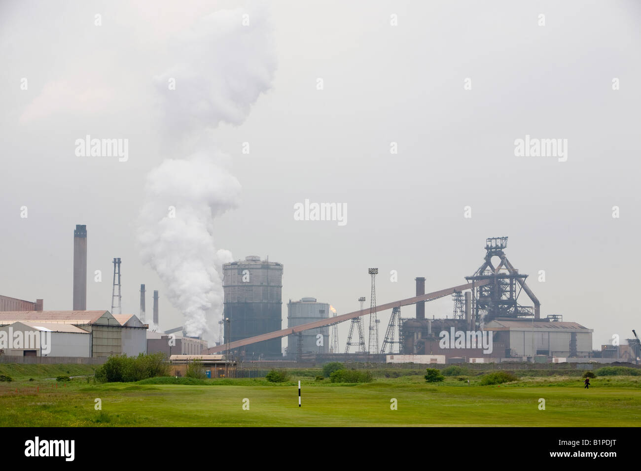 Golfers play on a golf course at Redcar on Teeside with a steel plant ...