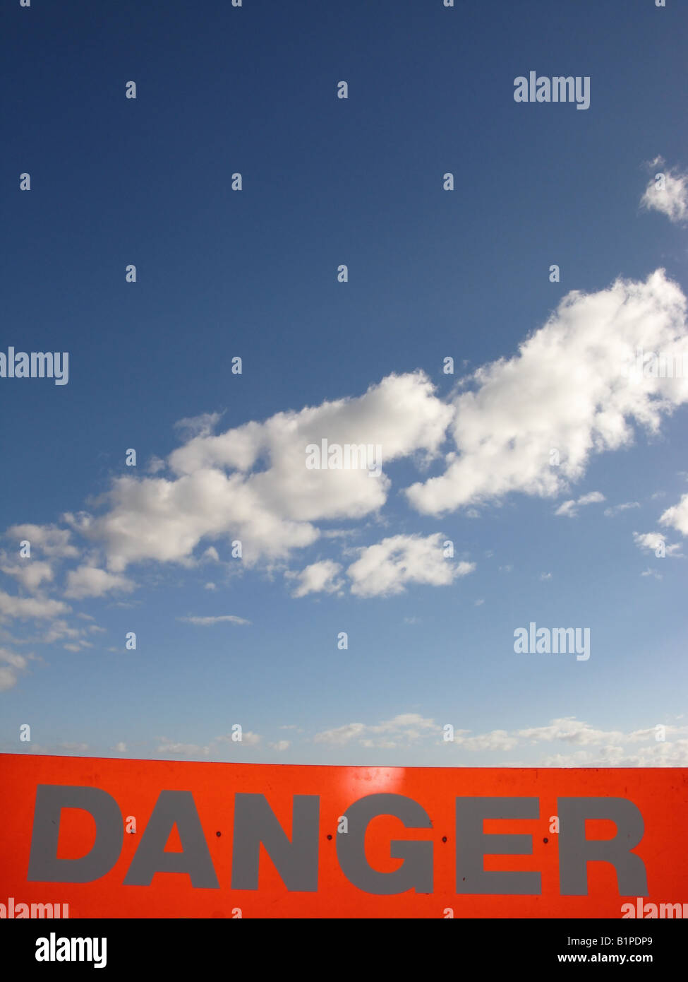 Red danger sign against blue cloudy sky Stock Photo - Alamy