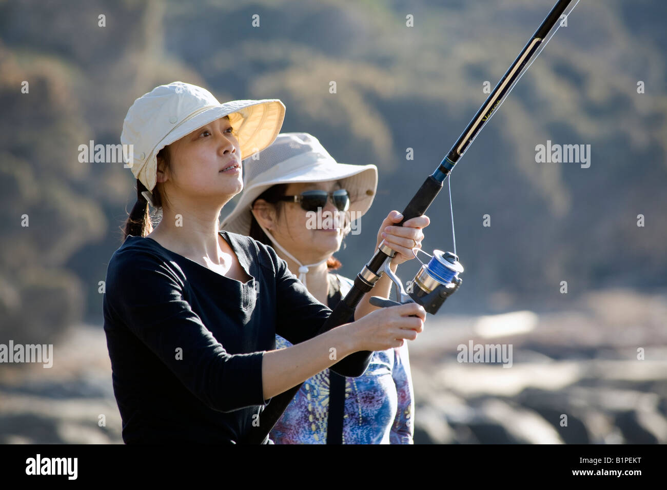 Portrait of a mother and daughter fishing Stock Photo - Alamy