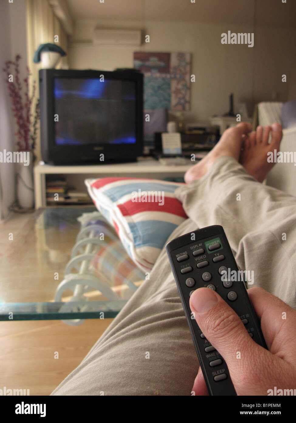 Detail of hand with remote control tv Stock Photo - Alamy