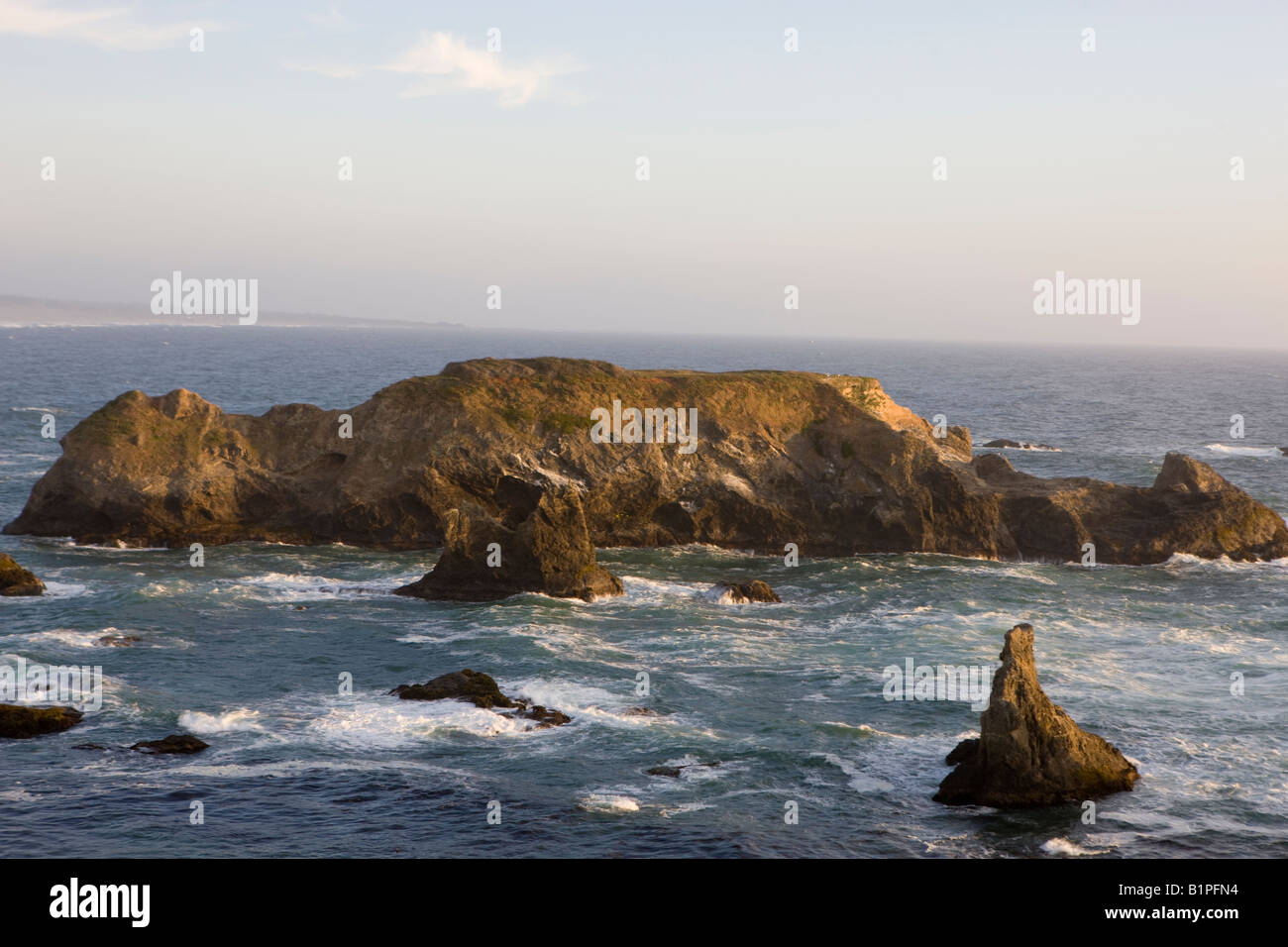 Steep cliffs and rocks line the shore of the Pacific Ocean along ...