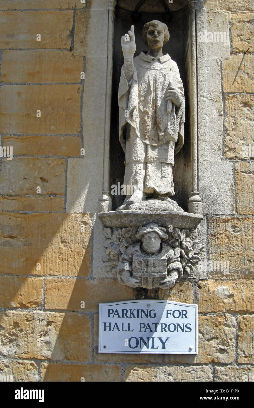 A stone of a saint with his finger raised with a sign below relating to ...