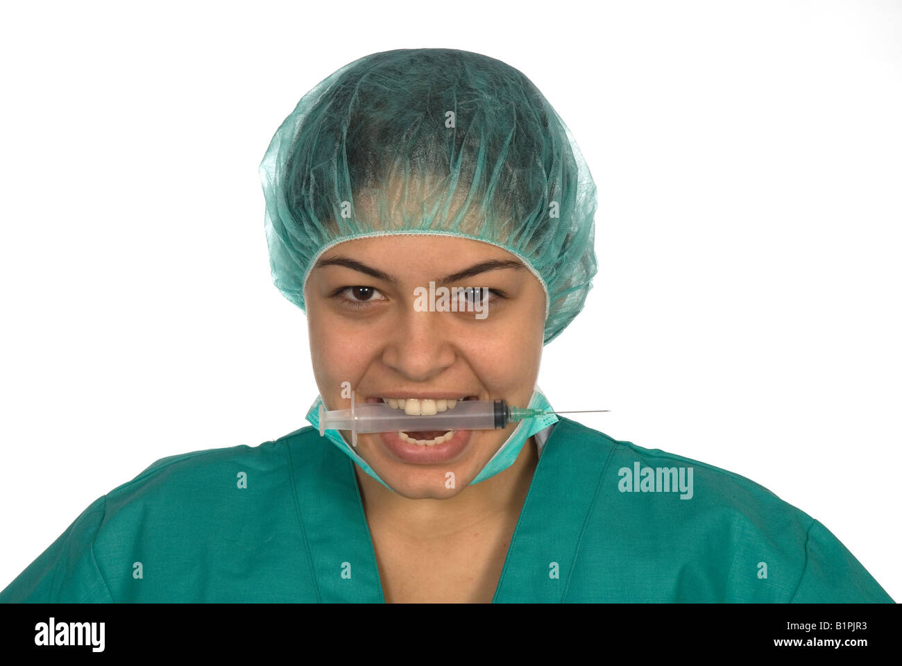 Scrubbed nurse biting Hypodermic injection against a white background ...