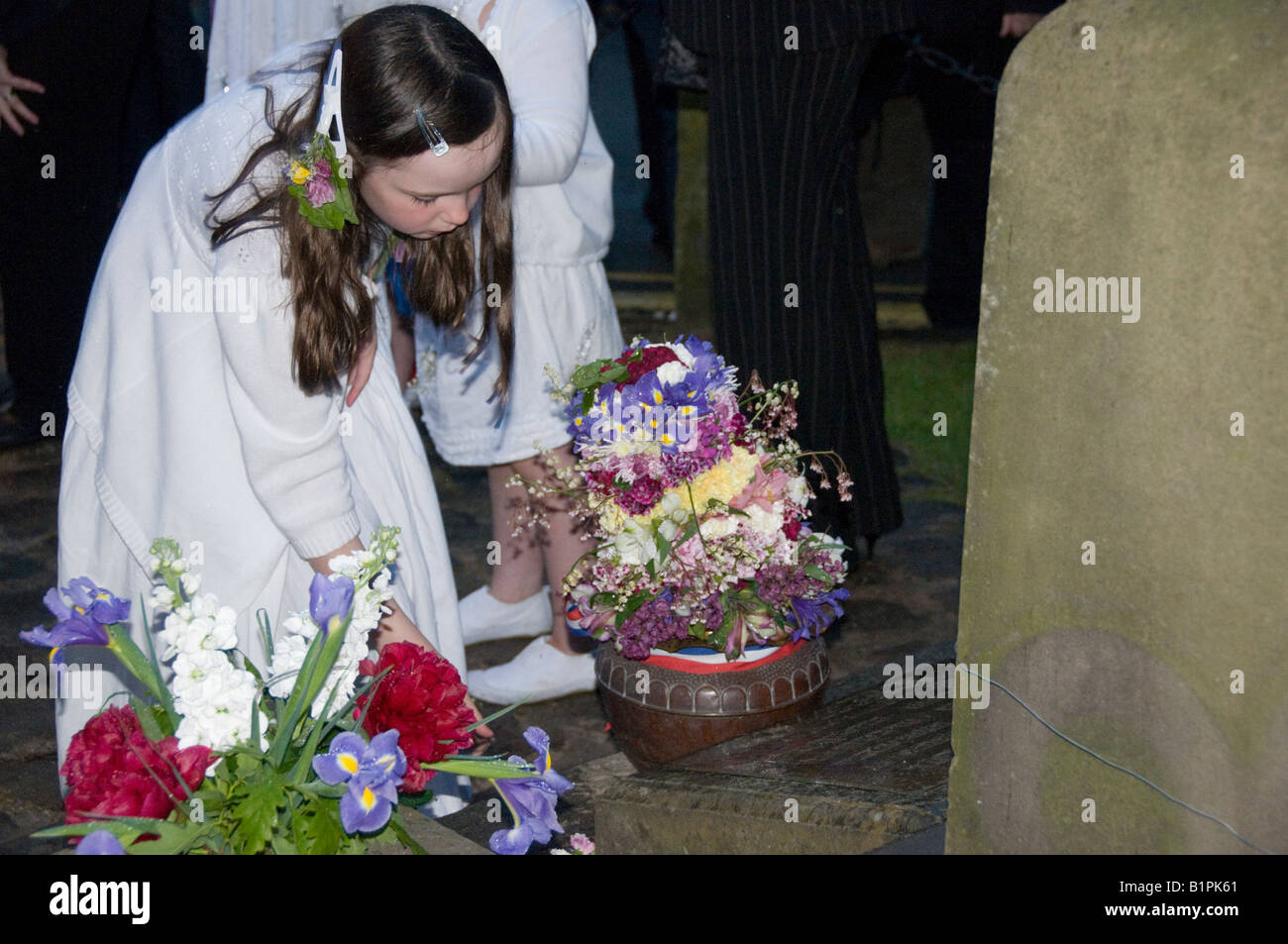 young girl laying flowers at church service in Castleton Derbyshire ...